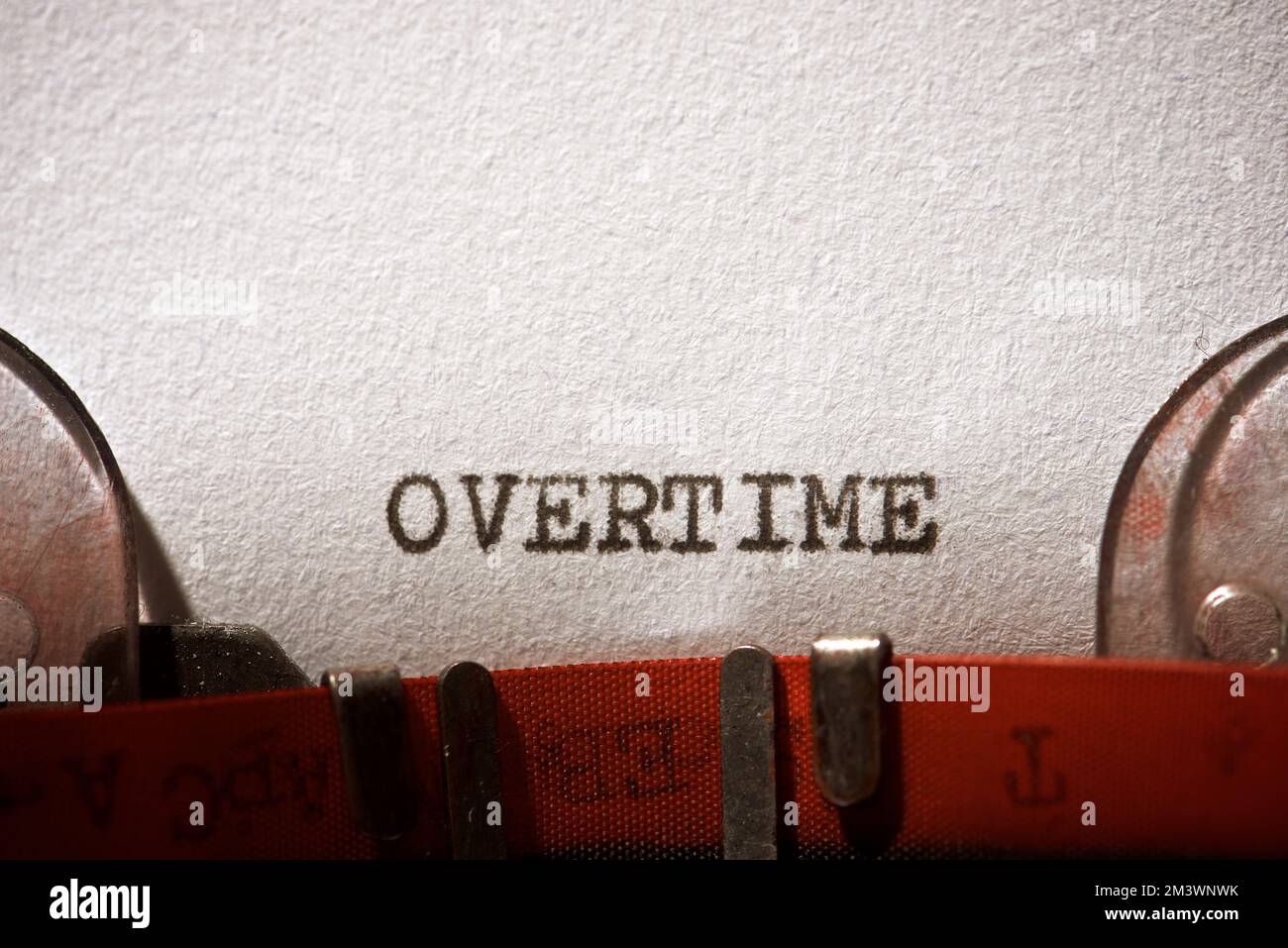 Overtime word written with a typewriter Stock Photo - Alamy