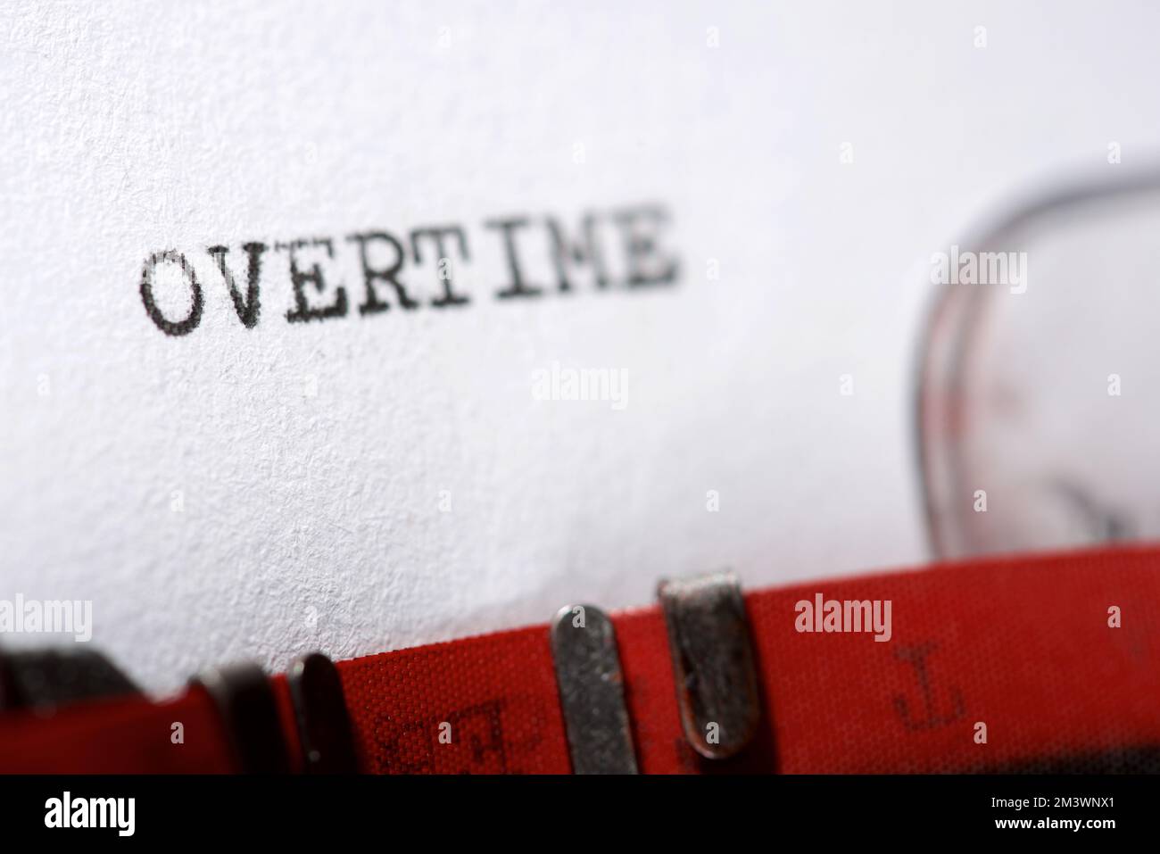 Overtime word written with a typewriter Stock Photo - Alamy