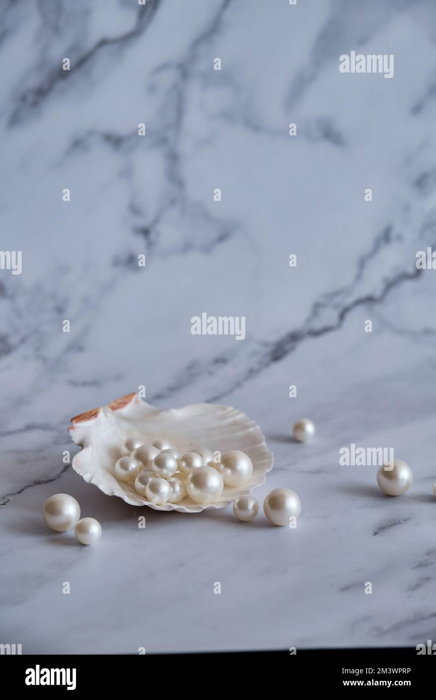 pearls in a shell on a marble background Stock Photo - Alamy