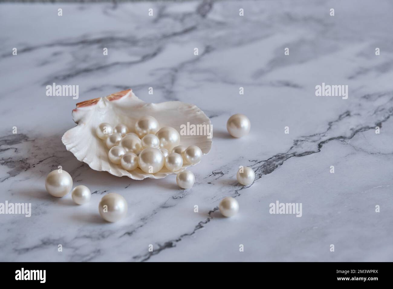 pearls in a shell on a marble background Stock Photo - Alamy