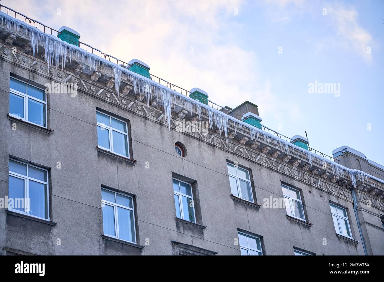 Large icicles hanging on the roof of the house in winter time Stock ...