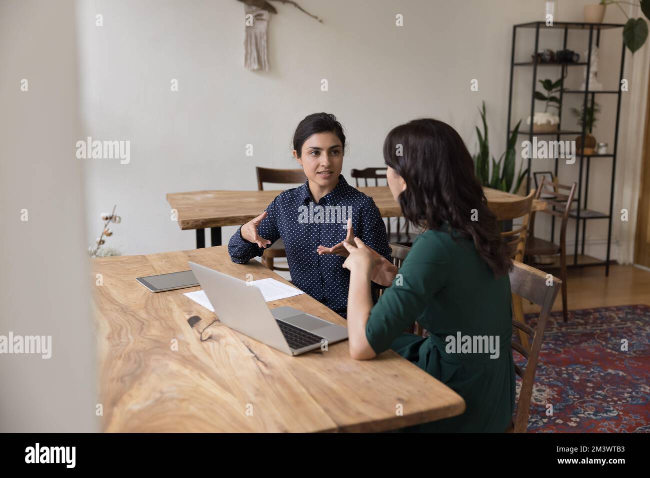 Serious Indian business leader woman talking to colleague at workplace ...