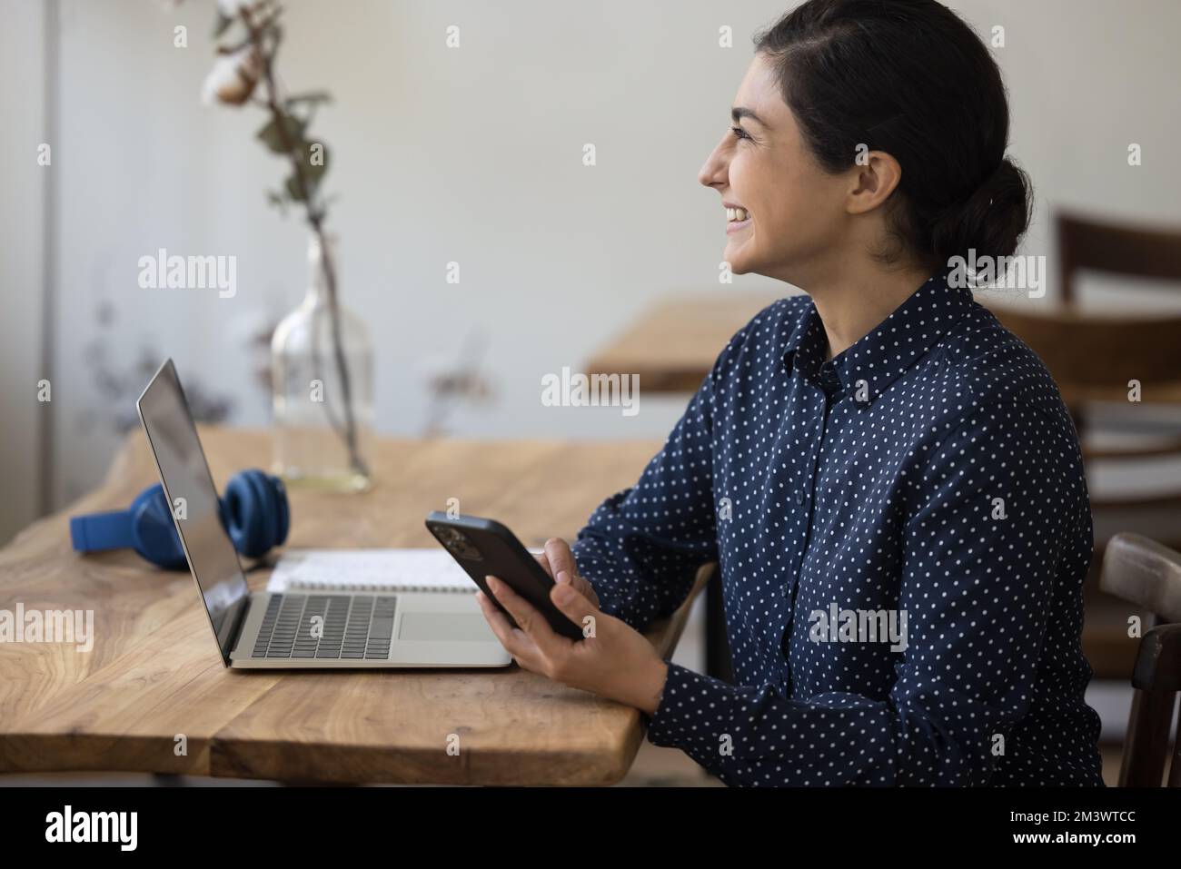 Dreamy young Indian freelance business woman holding smartphone Stock ...