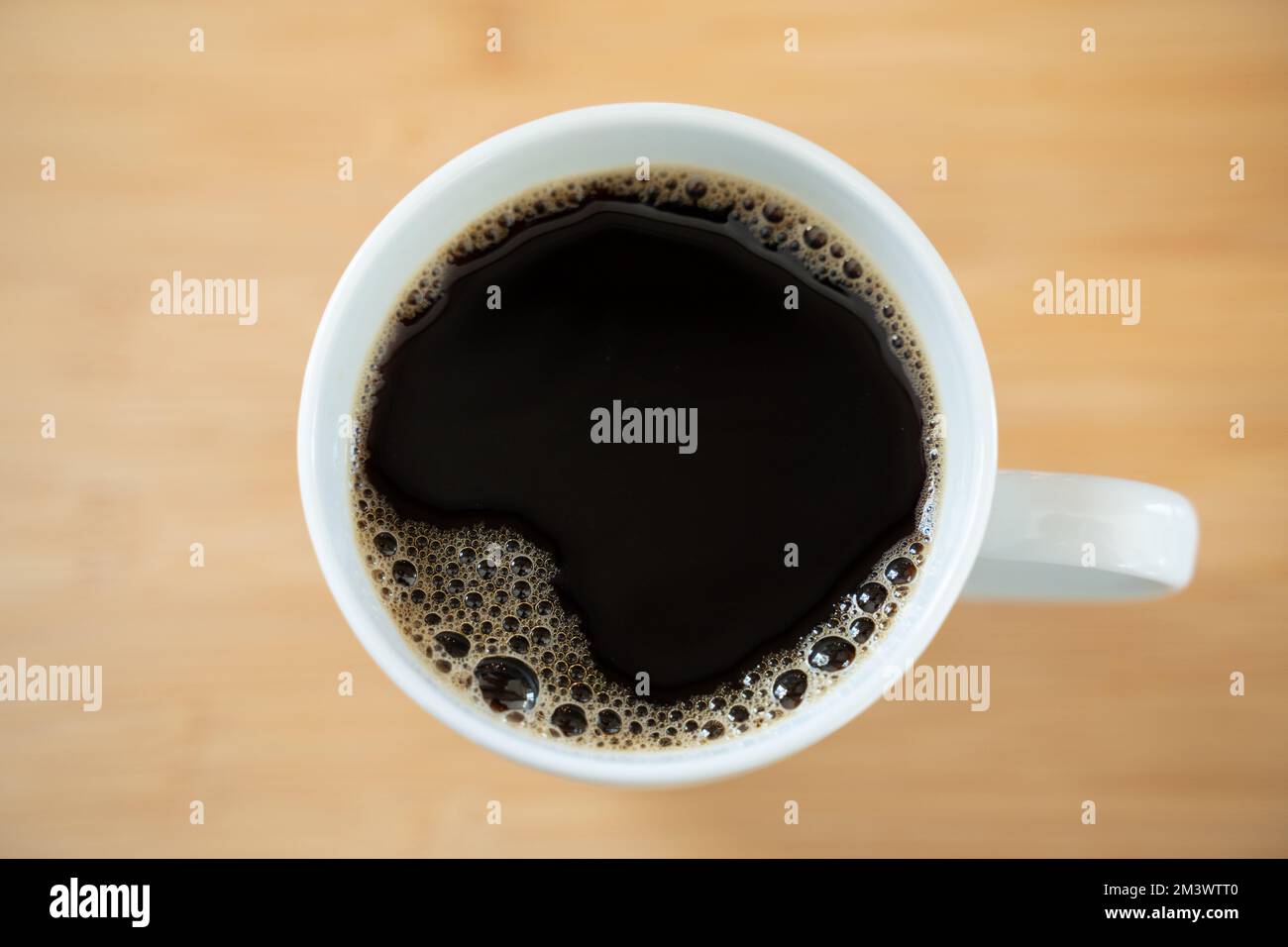 A top view of a cup of coffee with foam on a table Stock Photo - Alamy