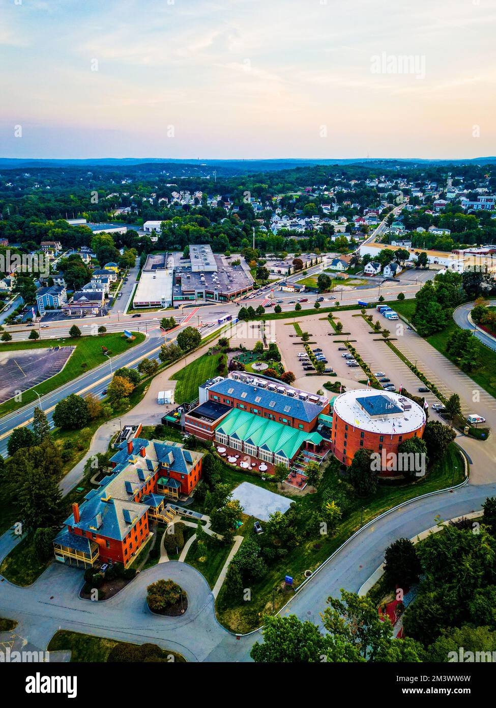 An aerial shot of a hotel and a green park with cultivated plants in ...