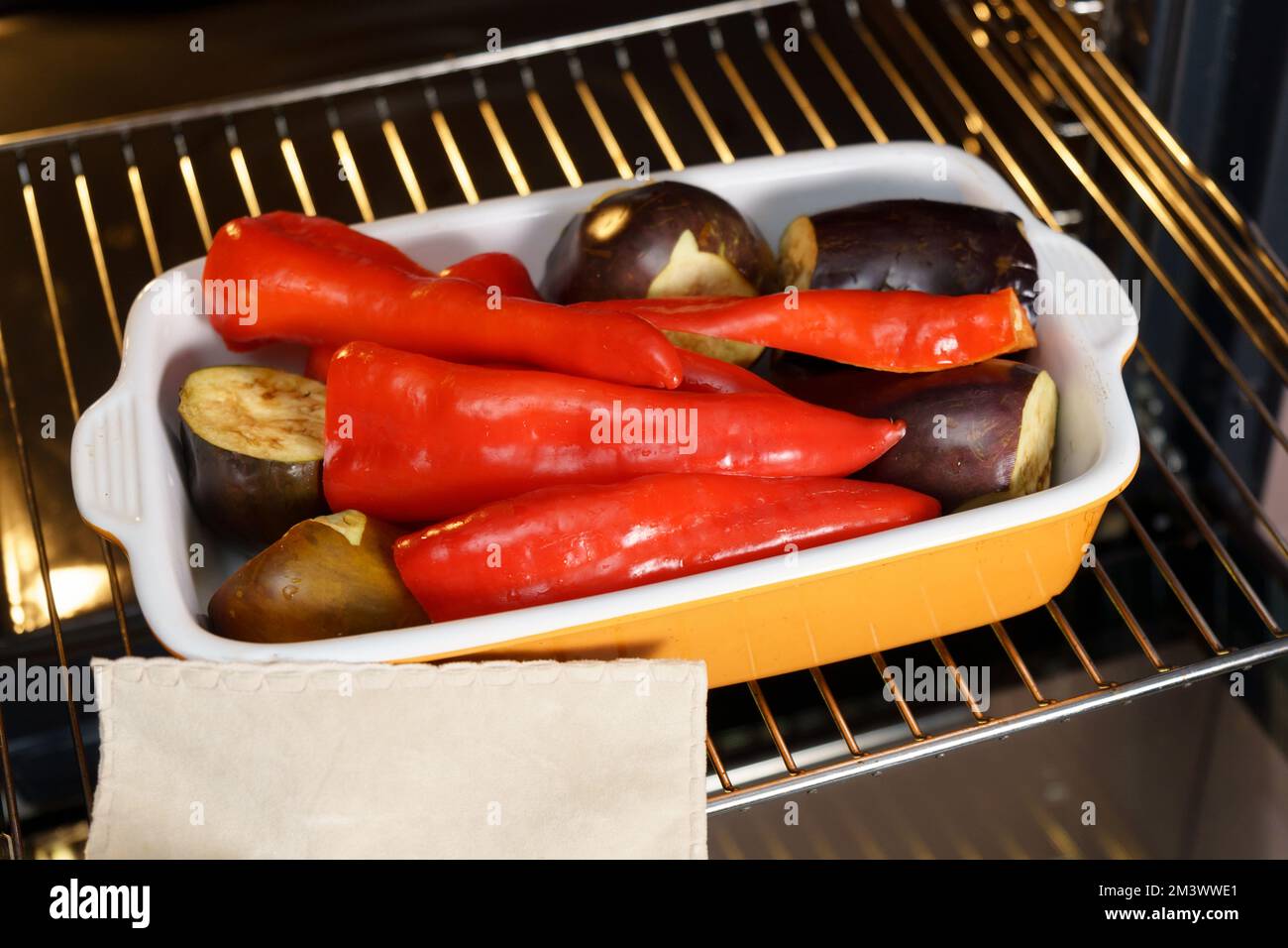Red peppers and eggplant roasting on stove in preparation for making ...