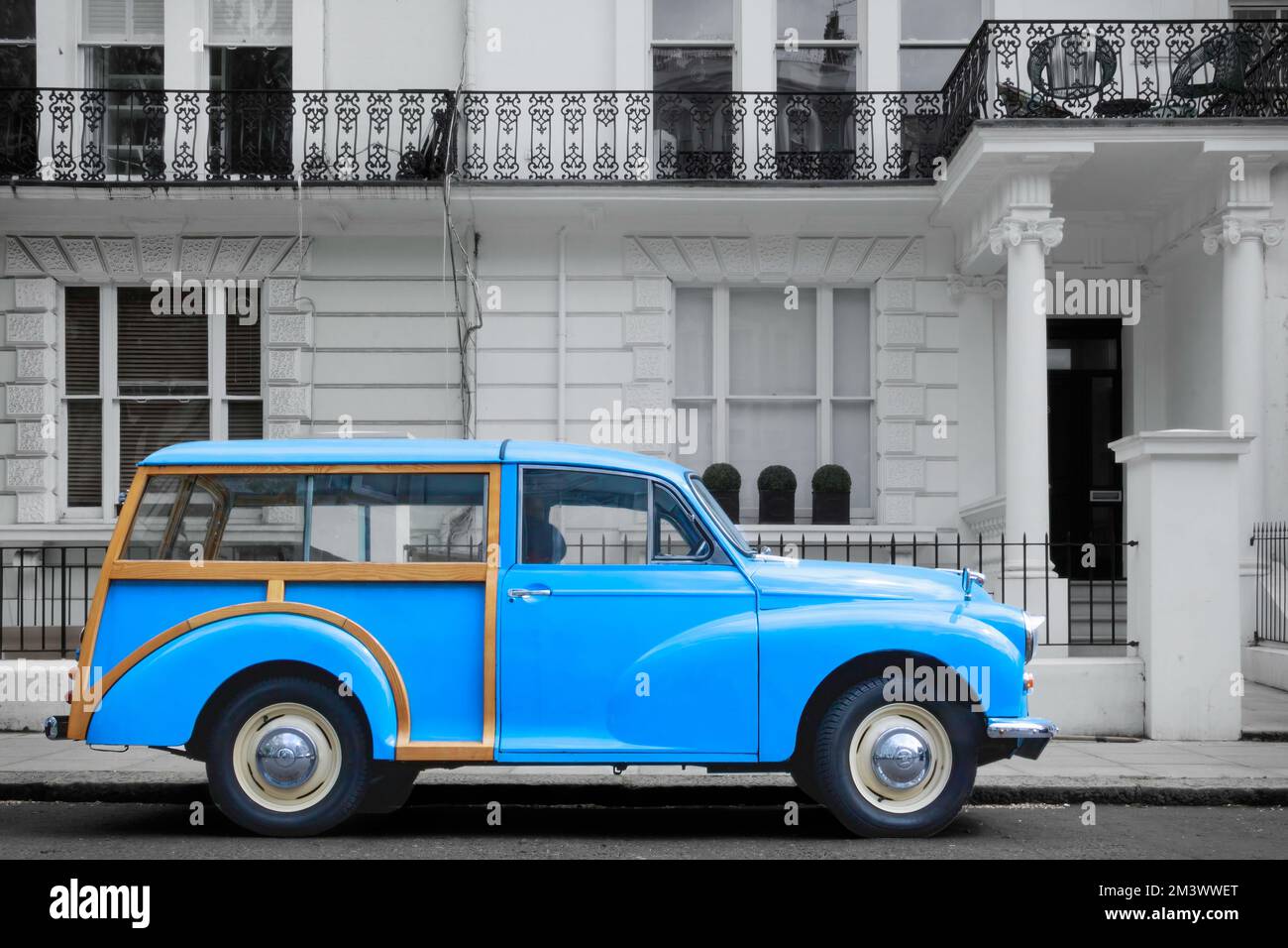 British blue oldtimer from 50s or 60s in front of white Victorian ...