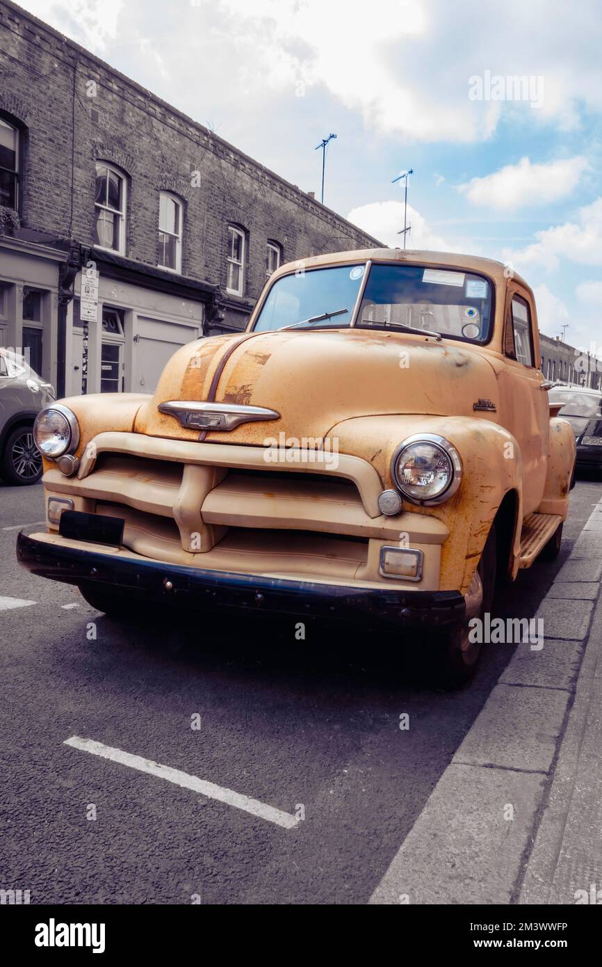 American yellow oldtimer from 50s or 60s parked in a London street, UK ...