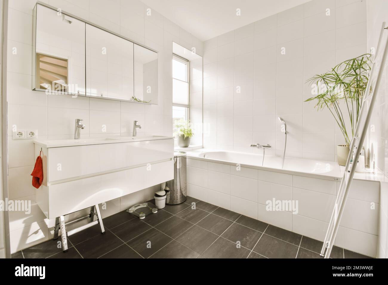 a bathroom with black tile flooring and white tiles on the walls there ...