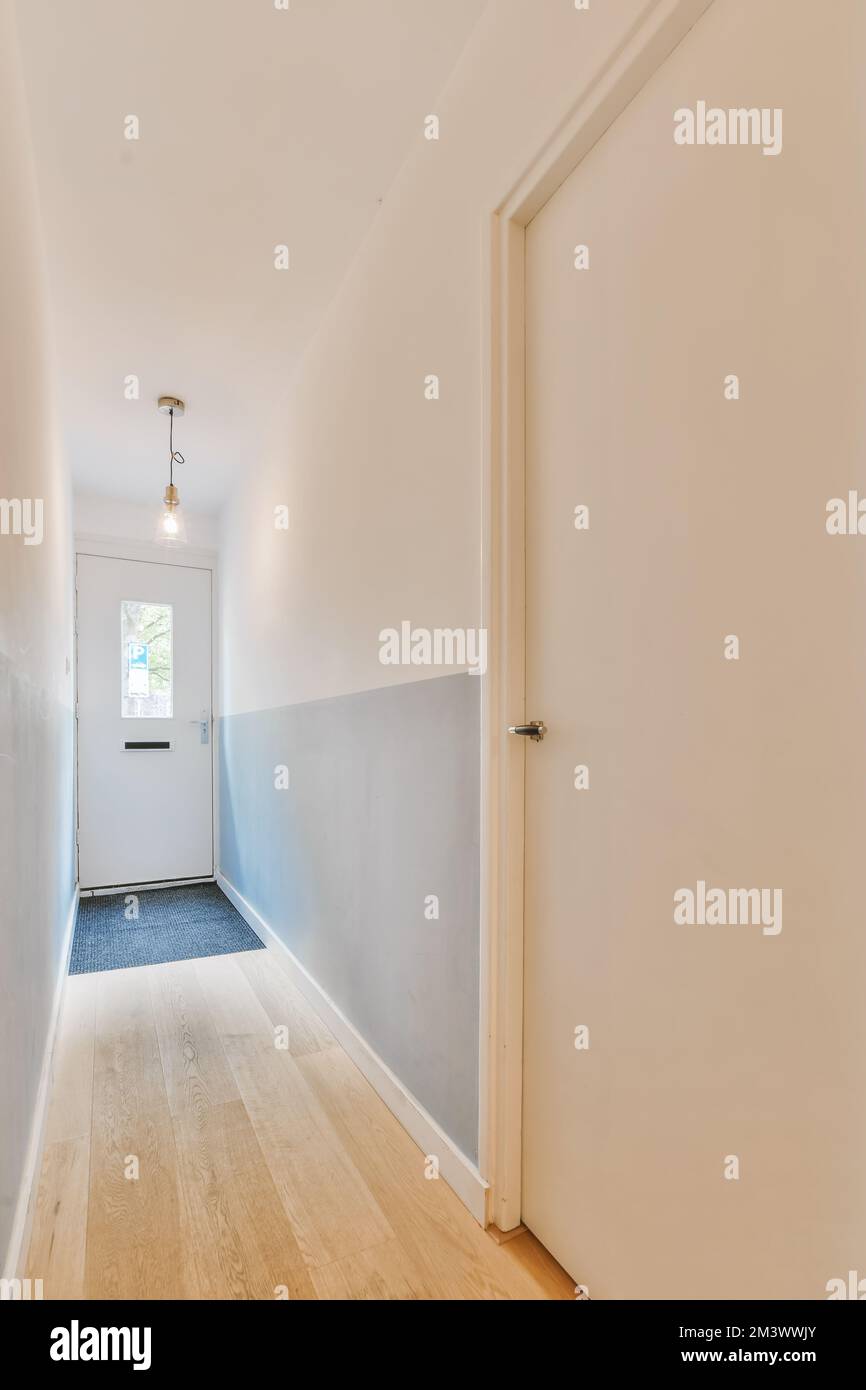 an empty hallway with wood floors and white walls, the door is open to ...