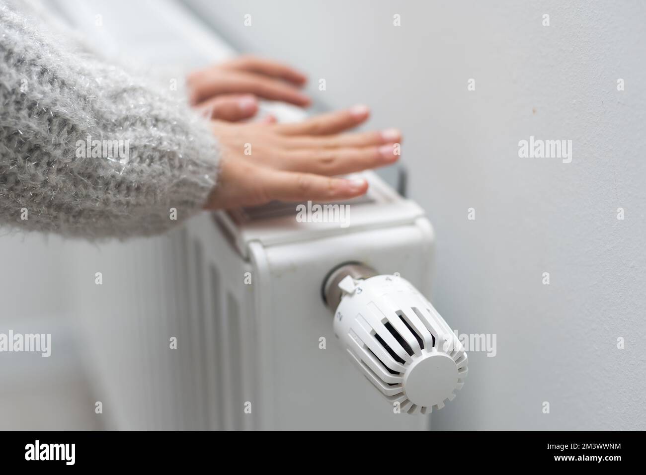 The child's hands warm their hands near the heating radiator. Saving ...