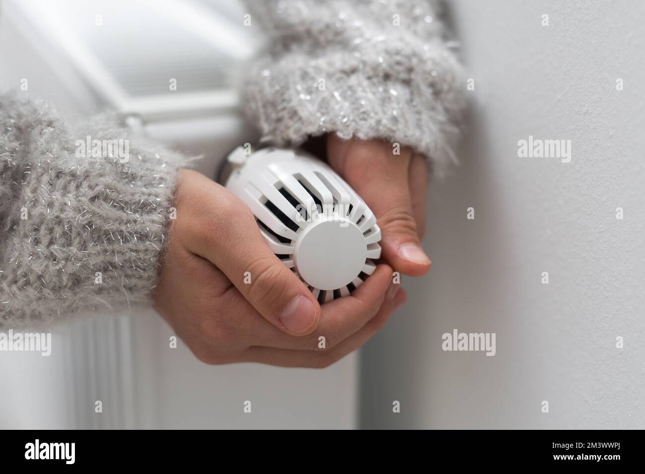 The child's hands warm their hands near the heating radiator. Saving ...