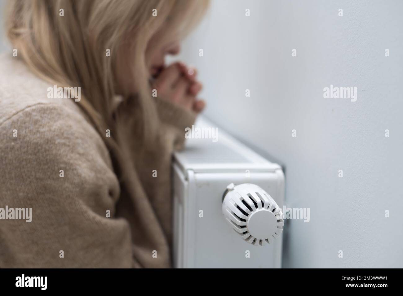 Closeup of woman warming her hands on the heater at home during cold ...