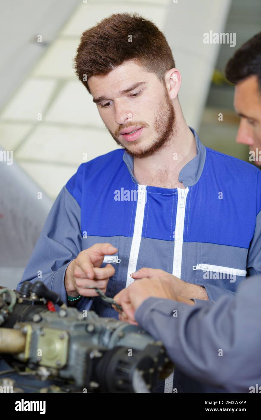 young mechanic helping in assembling parts Stock Photo - Alamy