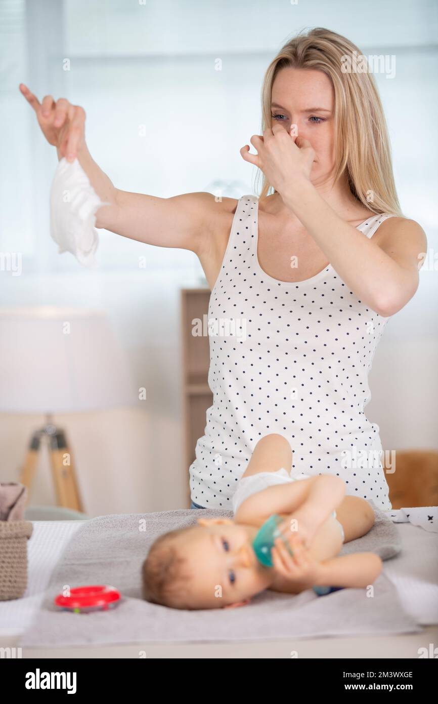 mother changing smelly baby diaper Stock Photo - Alamy