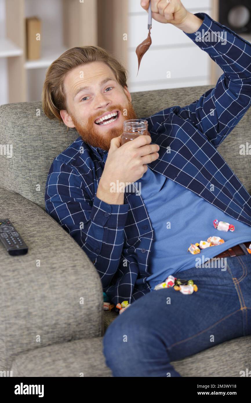 man covered in sweets eating chocolate spread from the jar Stock Photo ...