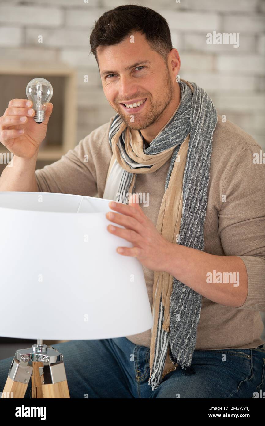 happy man changes an electric light bulb Stock Photo - Alamy