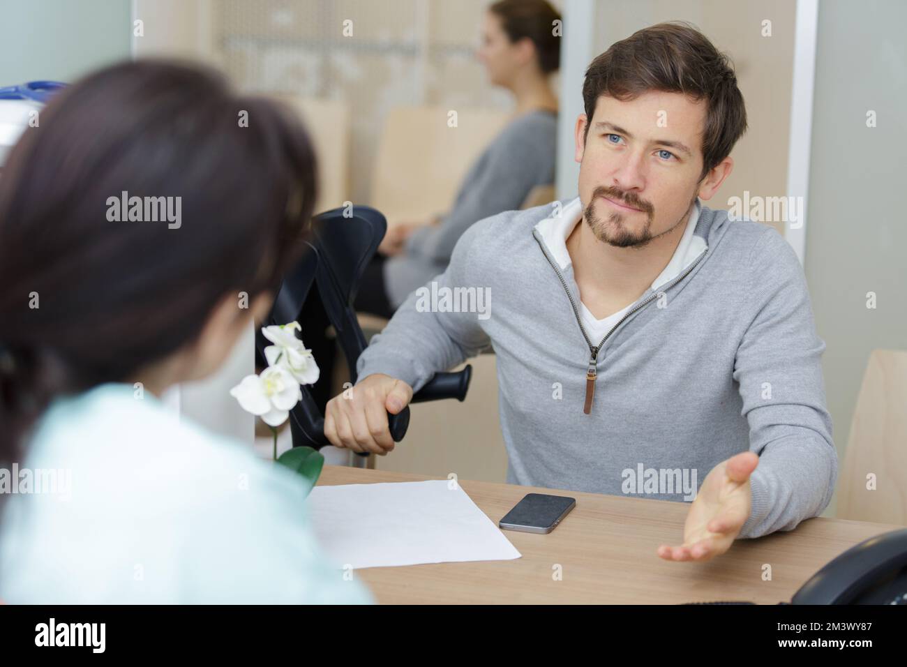 a handsome male worker talking to secretary Stock Photo - Alamy