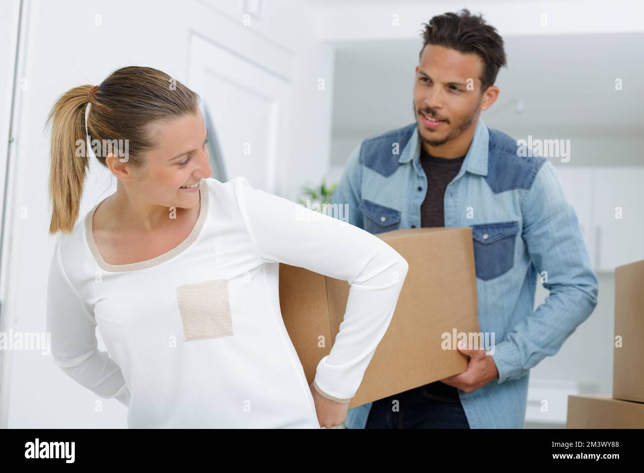young couple carrying big cardboard box in new home Stock Photo - Alamy