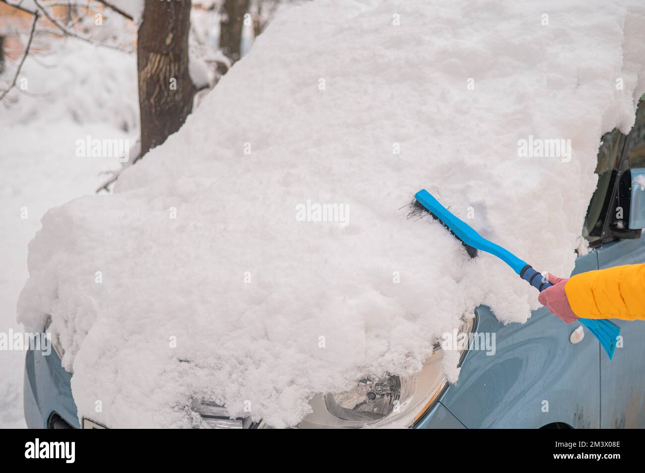 Caucasian woman brushing a car from freshly fallen snow Stock Photo - Alamy