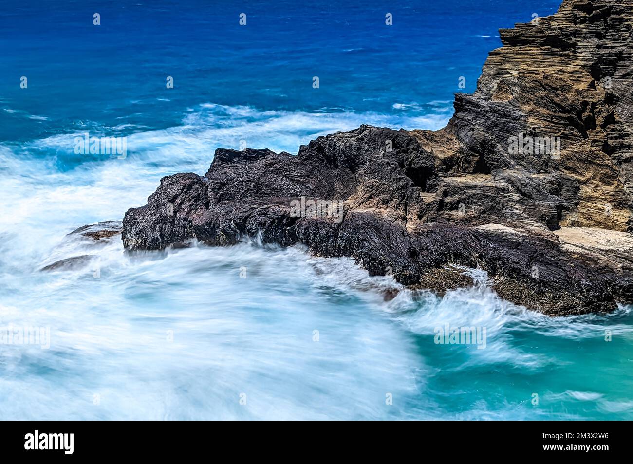 A beautiful scene of the blue ocean waves crashing on the cliffs in ...