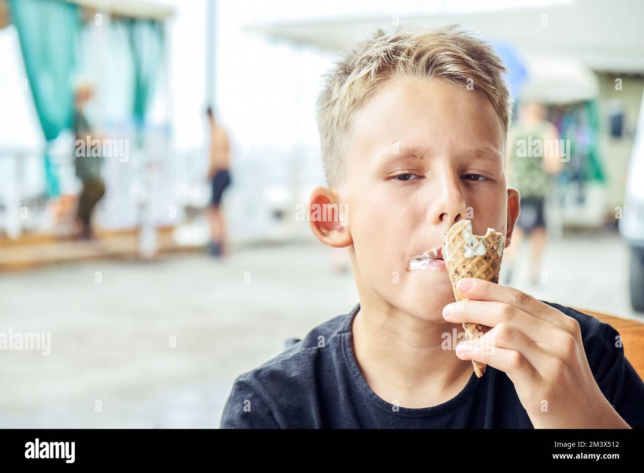 Junior schoolboy enjoys eating ice cream and spending summer holidays ...