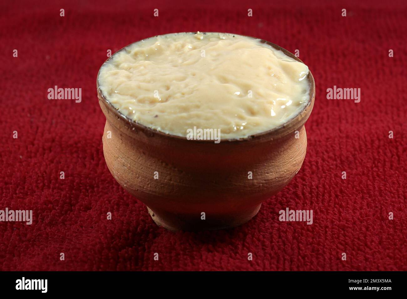 A bowl of Bengali sweet curd isolated on red background Stock Photo - Alamy