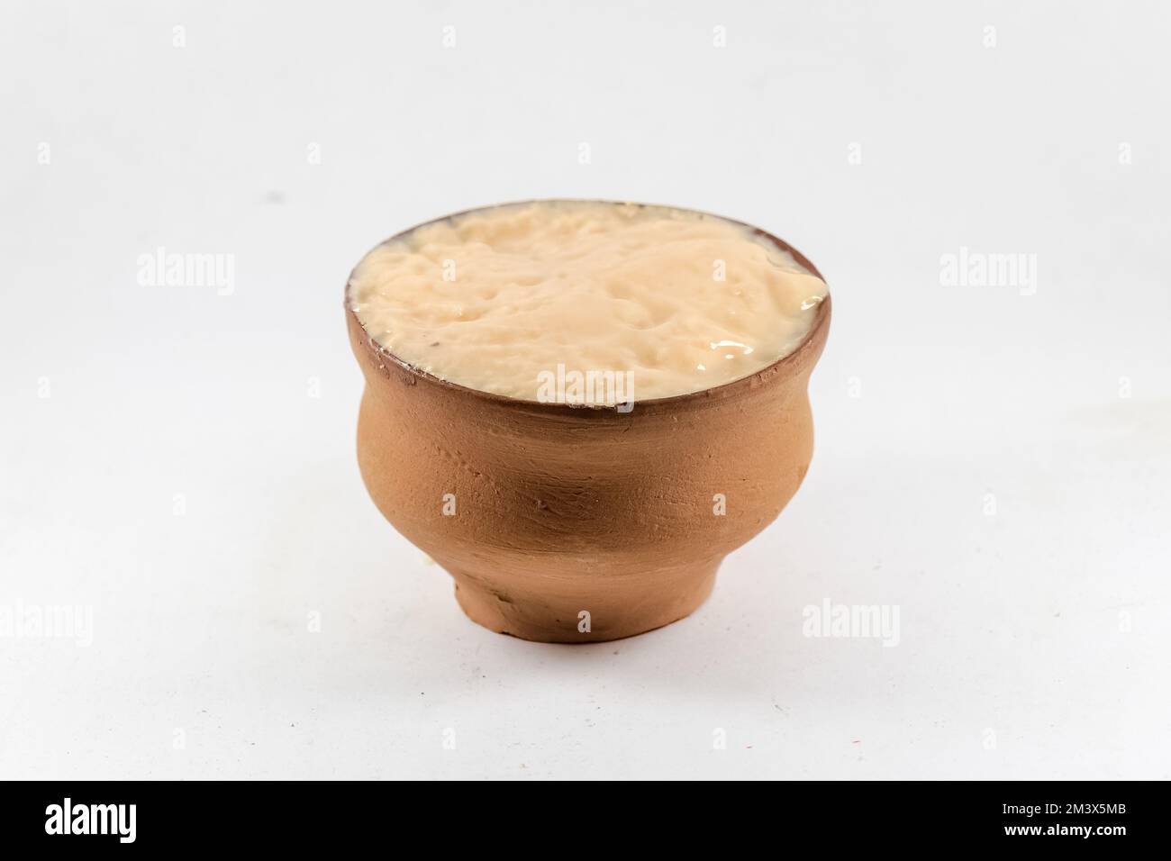 A bowl of Mishti Laal Doi or dahi or Bengali sweet curd isolated on ...