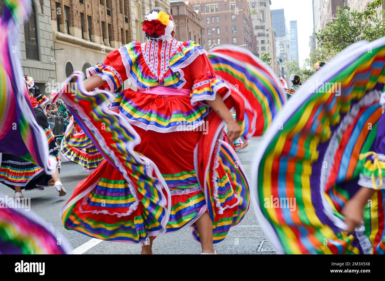 A group of dancers in colorful costumes performing during the Mexican ...