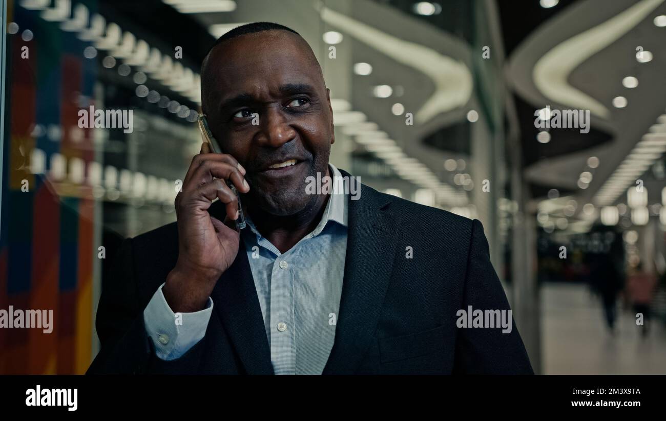 Smiling cheerful African middle-aged man entrepreneur businessman talk ...