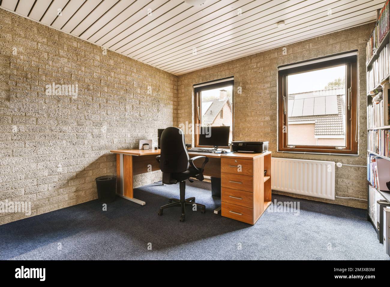 an office area with a desk, chair and bookshels on the floor in front ...