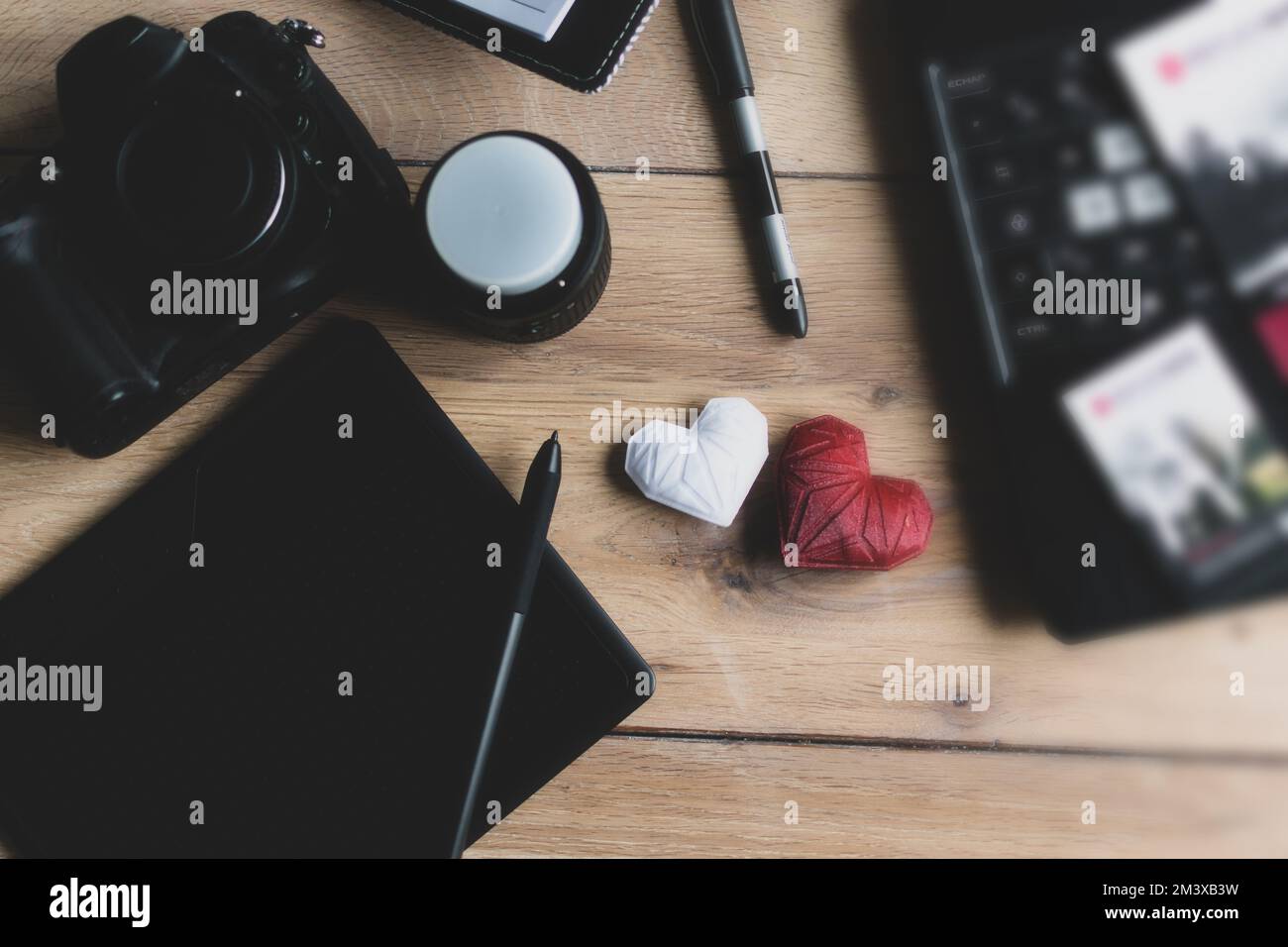 Graphic designer workstation with dslr, lens, laptop, agenda, stylus ...