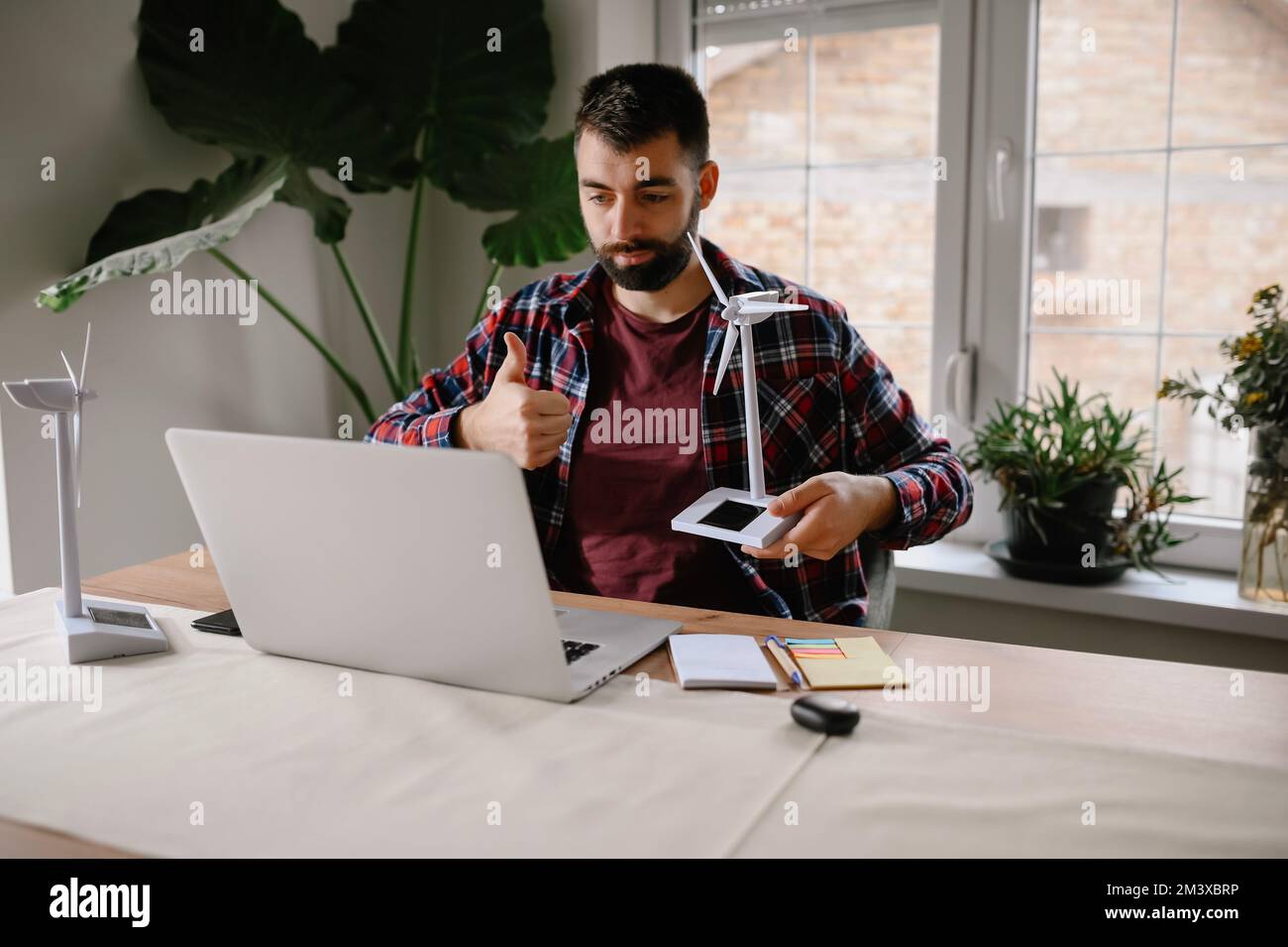 Young innovative dedicated bearded employee sitting in his modern ...