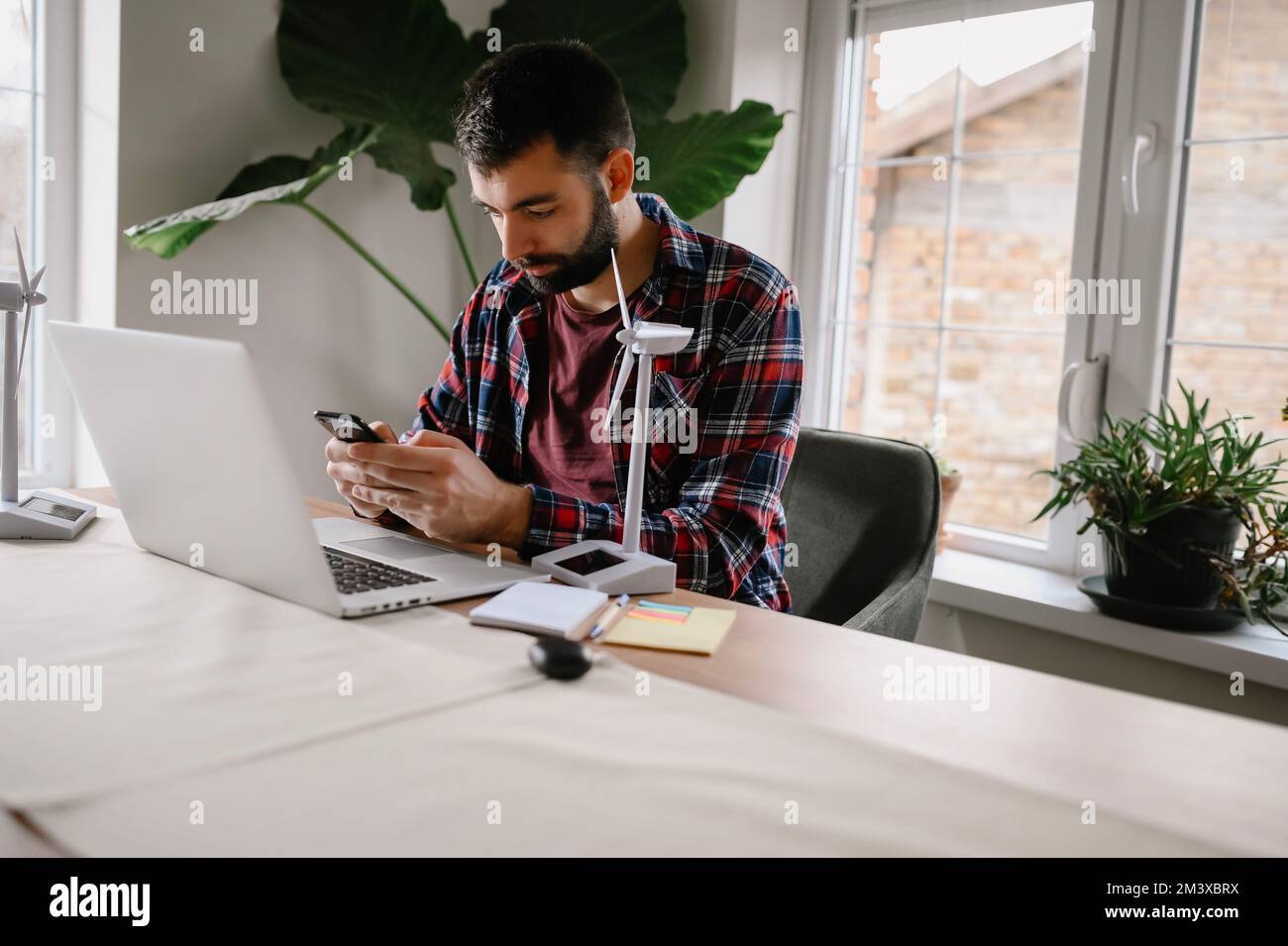 Young innovative dedicated bearded employee sitting in his modern ...
