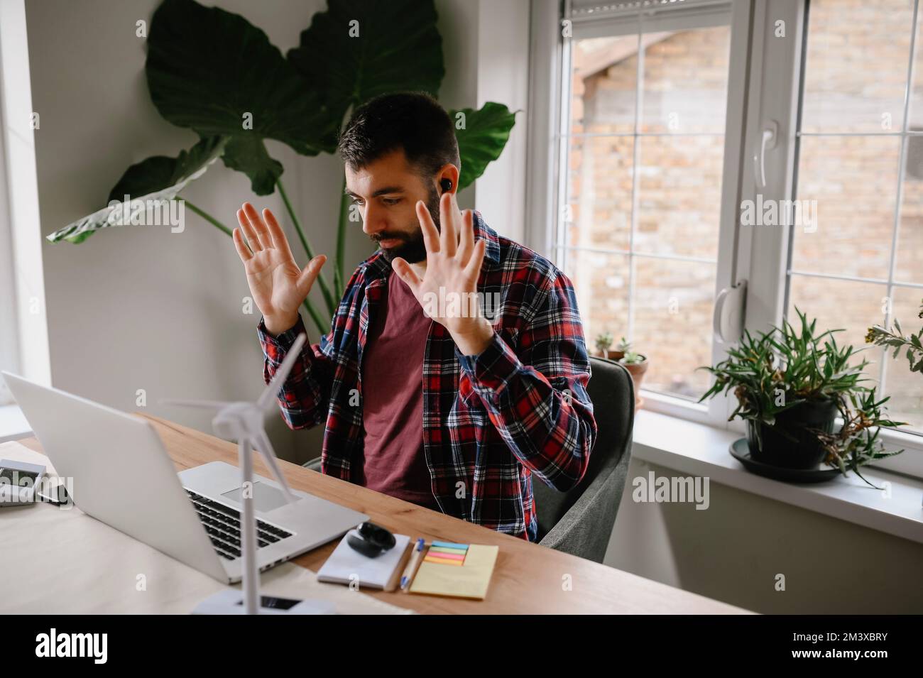 Young innovative dedicated bearded employee sitting in his modern ...
