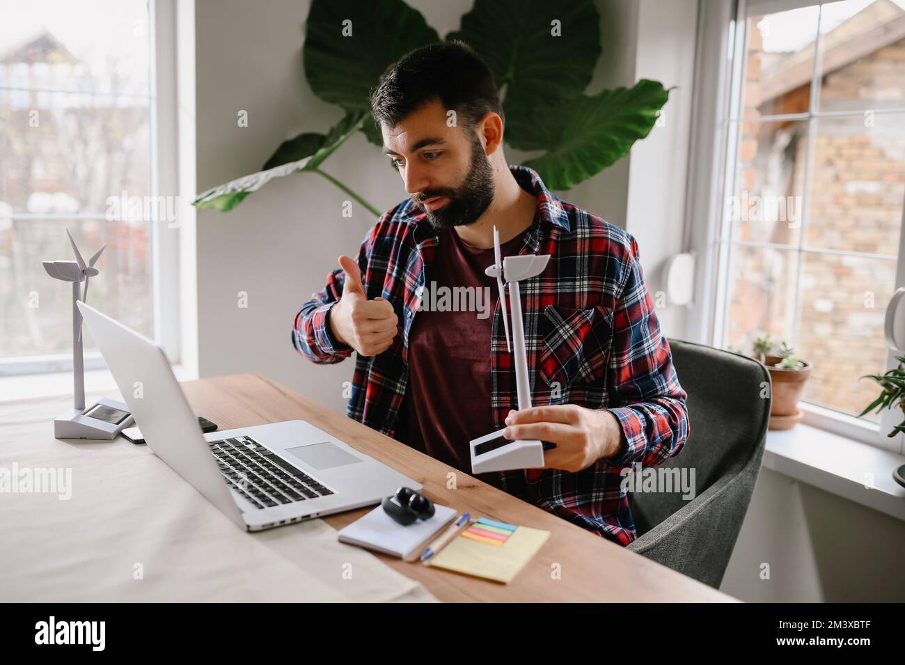 Young innovative dedicated bearded employee sitting in his modern ...