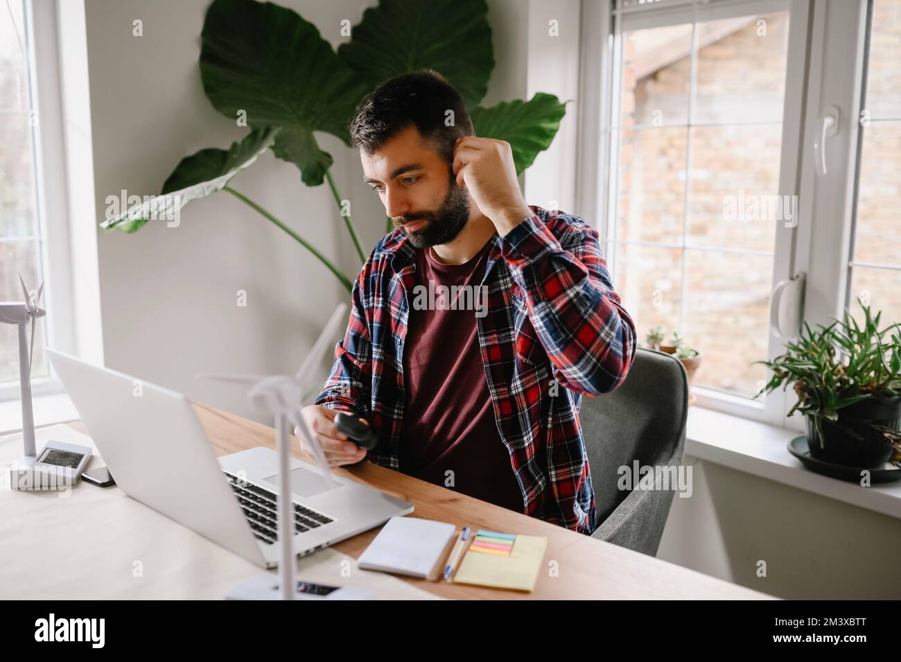 Young innovative dedicated bearded employee sitting in his modern ...