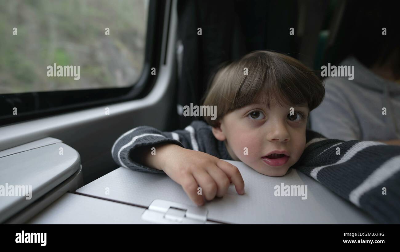 Child traveling by train. One bored little boy with nothing to do ...