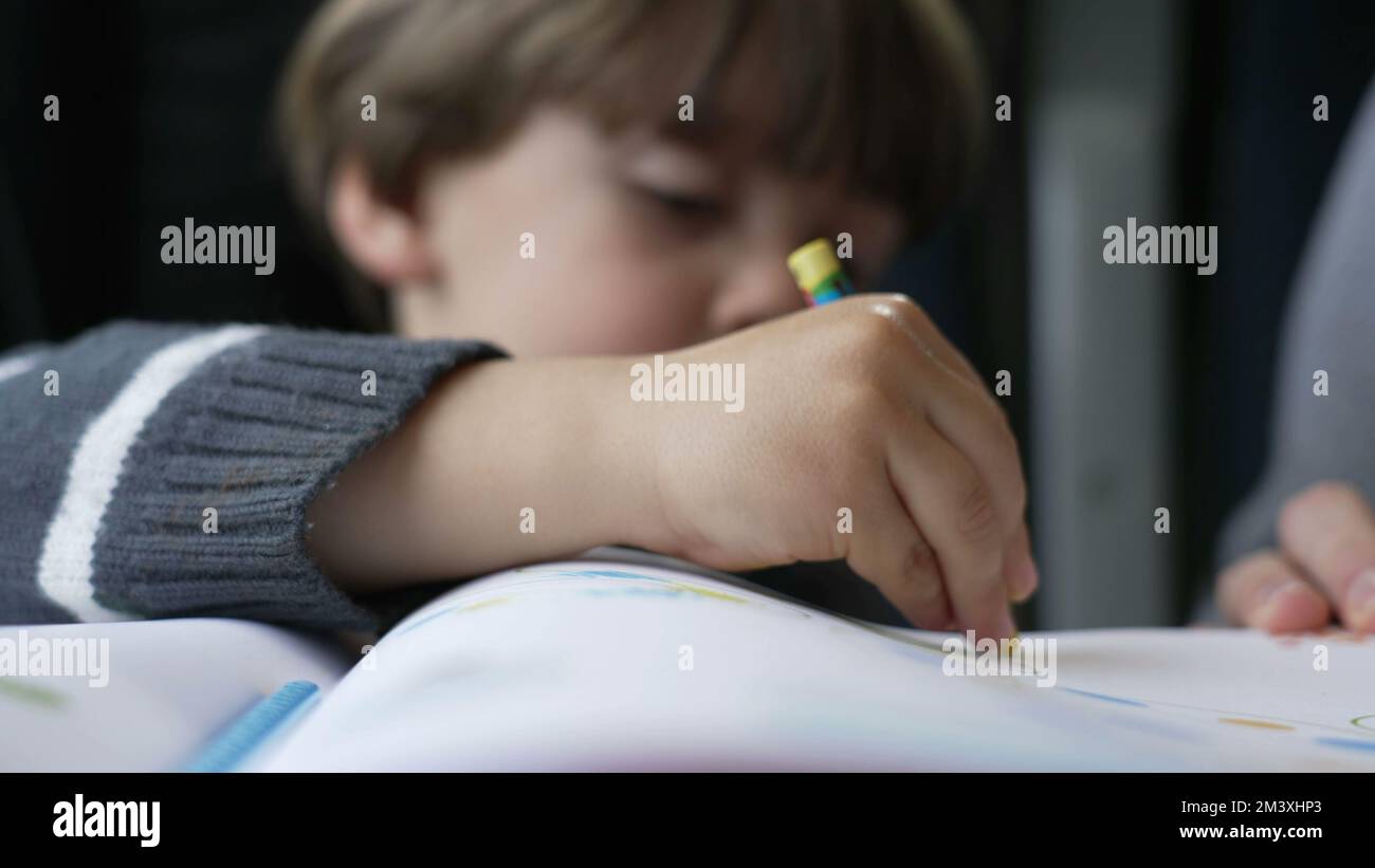 Child holding coloring pen on paper. One little boy doing homework on ...