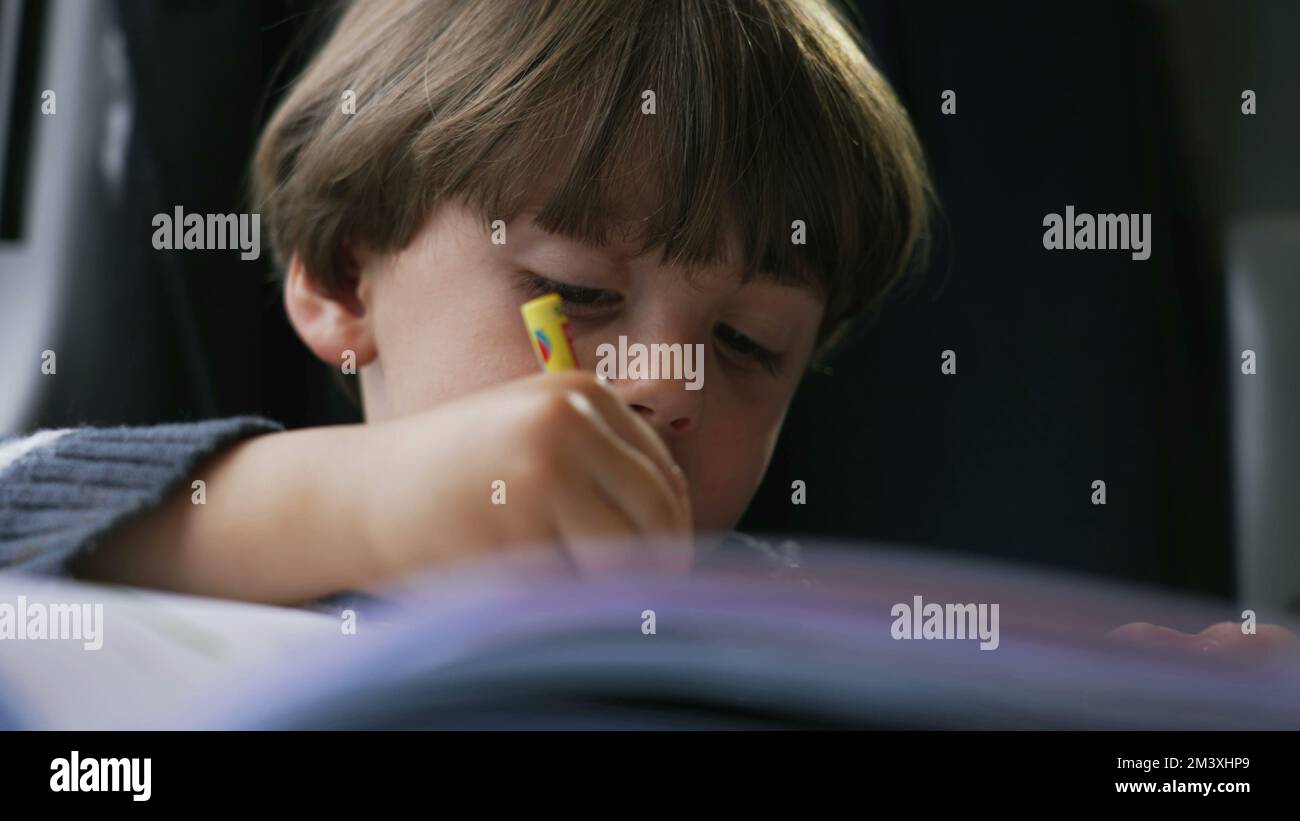 Focused child face drawing on paper. One concentrated little boy doing ...