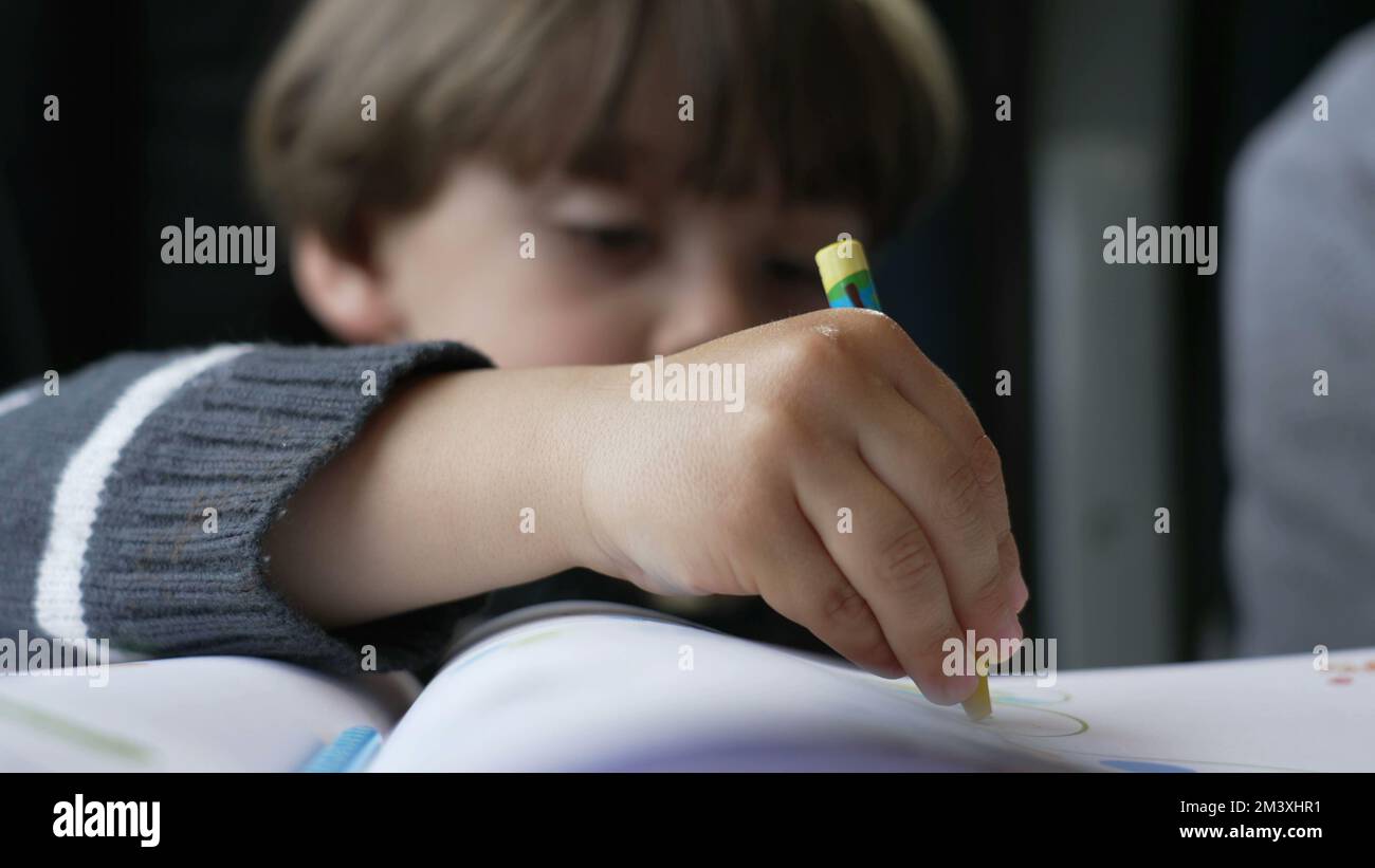 Child holding coloring pen on paper. One little boy doing homework on ...