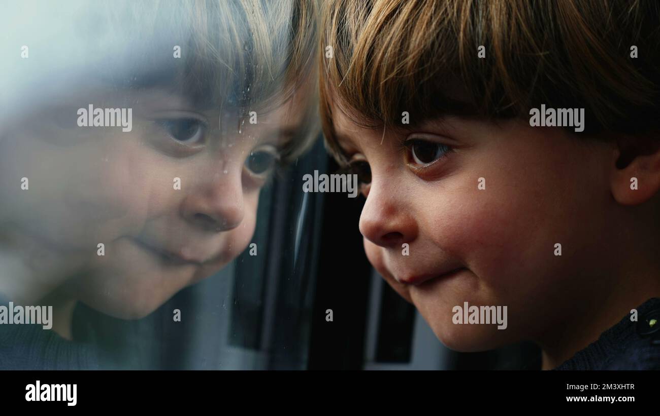 One pensive child leaning on train window. Mirror glass reflection of ...