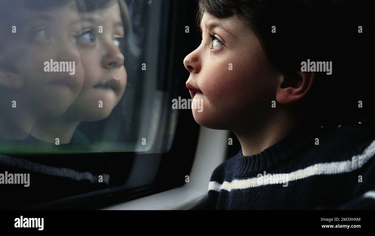 Passenger child by train window reflection. One little boy traveling ...