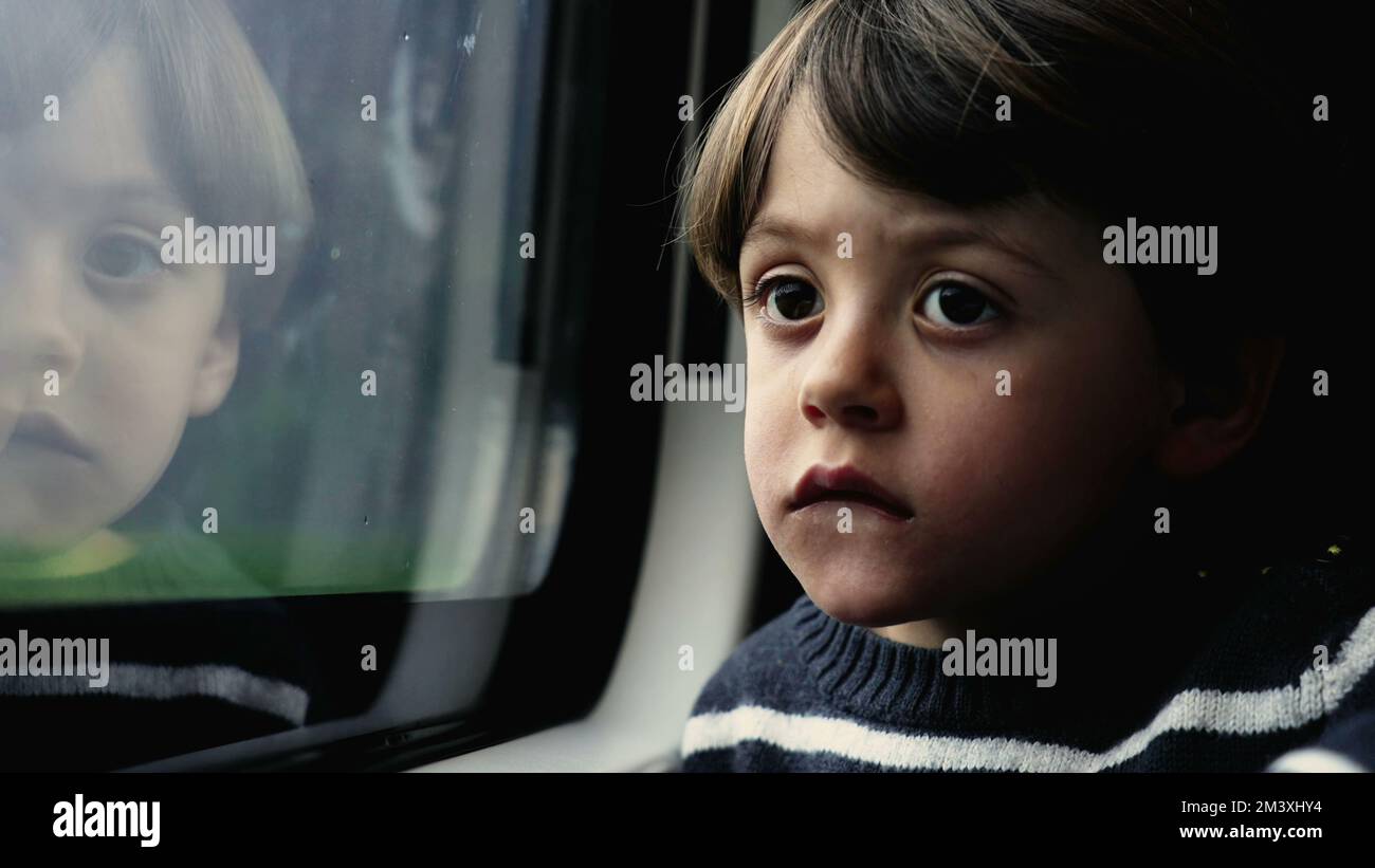 Passenger child by train window reflection. One little boy traveling ...