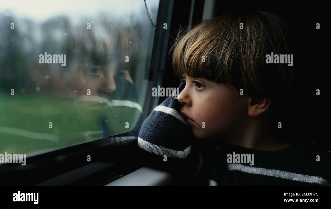 Thoughtful child staring at train window feeling sadness. Pensive ...