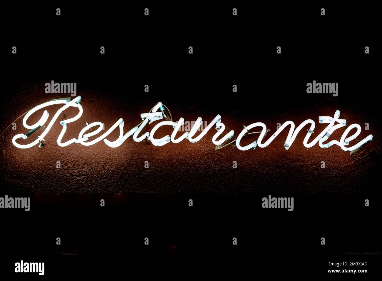 An orange neon sign saying "Restaurants" in Madrid Spain isolated on an ...