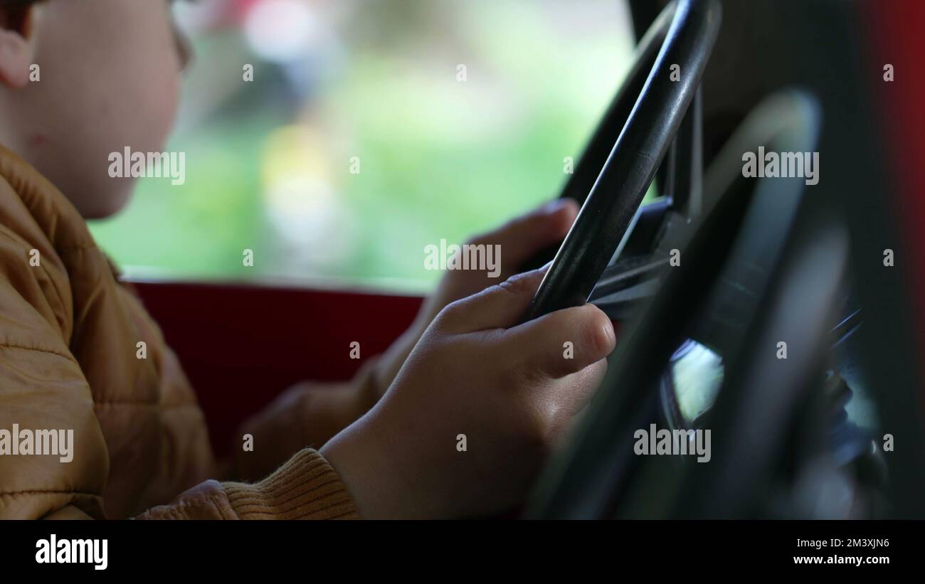 Child hands holding steering wheel pretending to be driving at ...