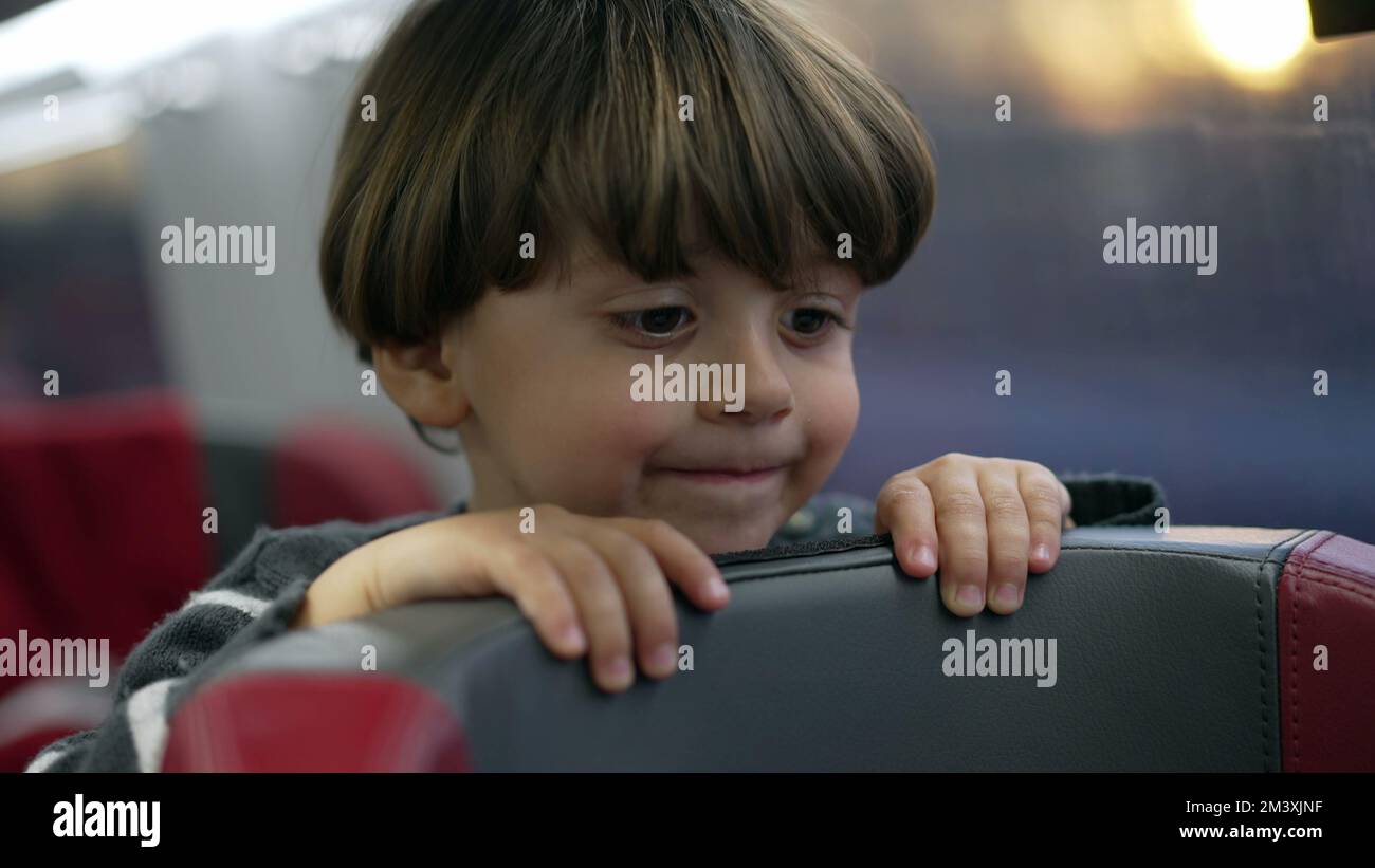 Child standing on train seat traveling inside high speed train. closeup ...