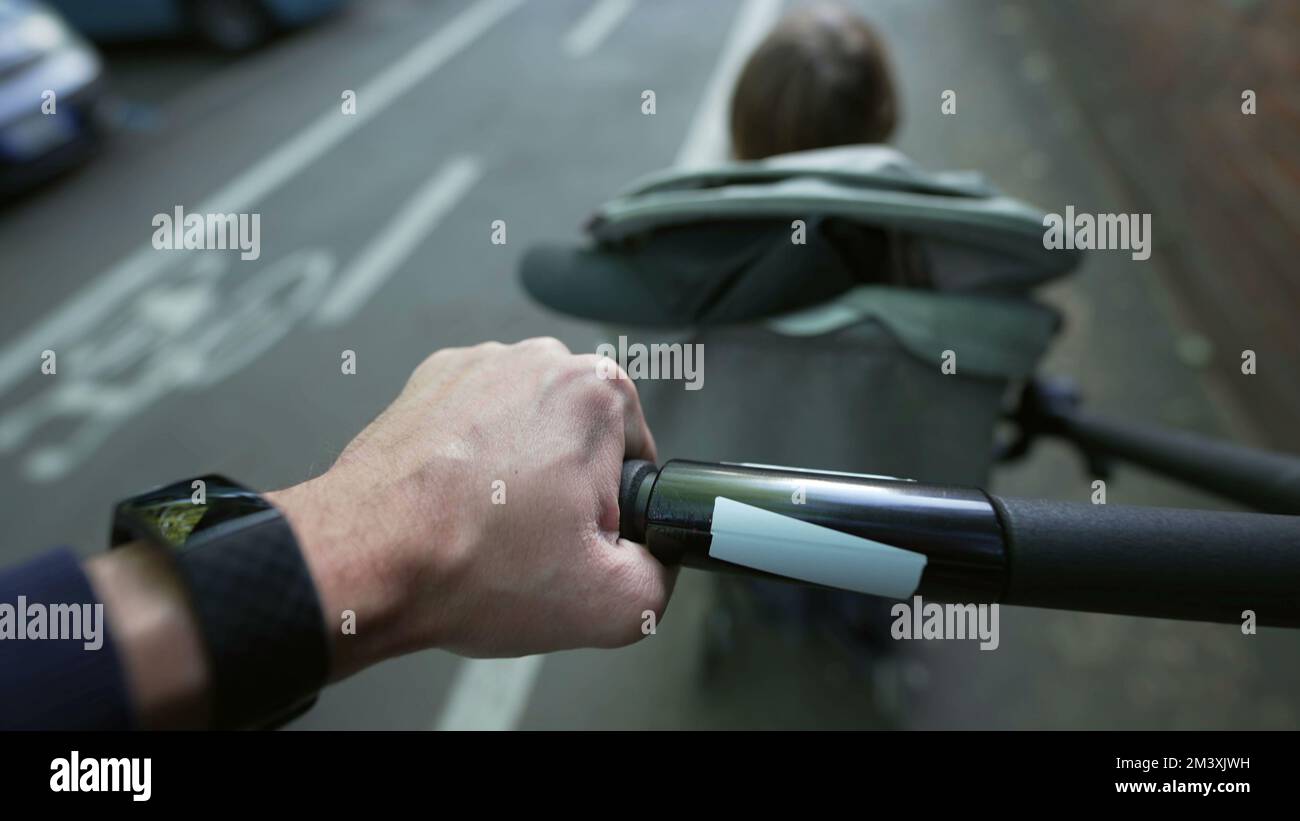 Father hand POV pushing baby carriage. Parent pushes stroller outside ...