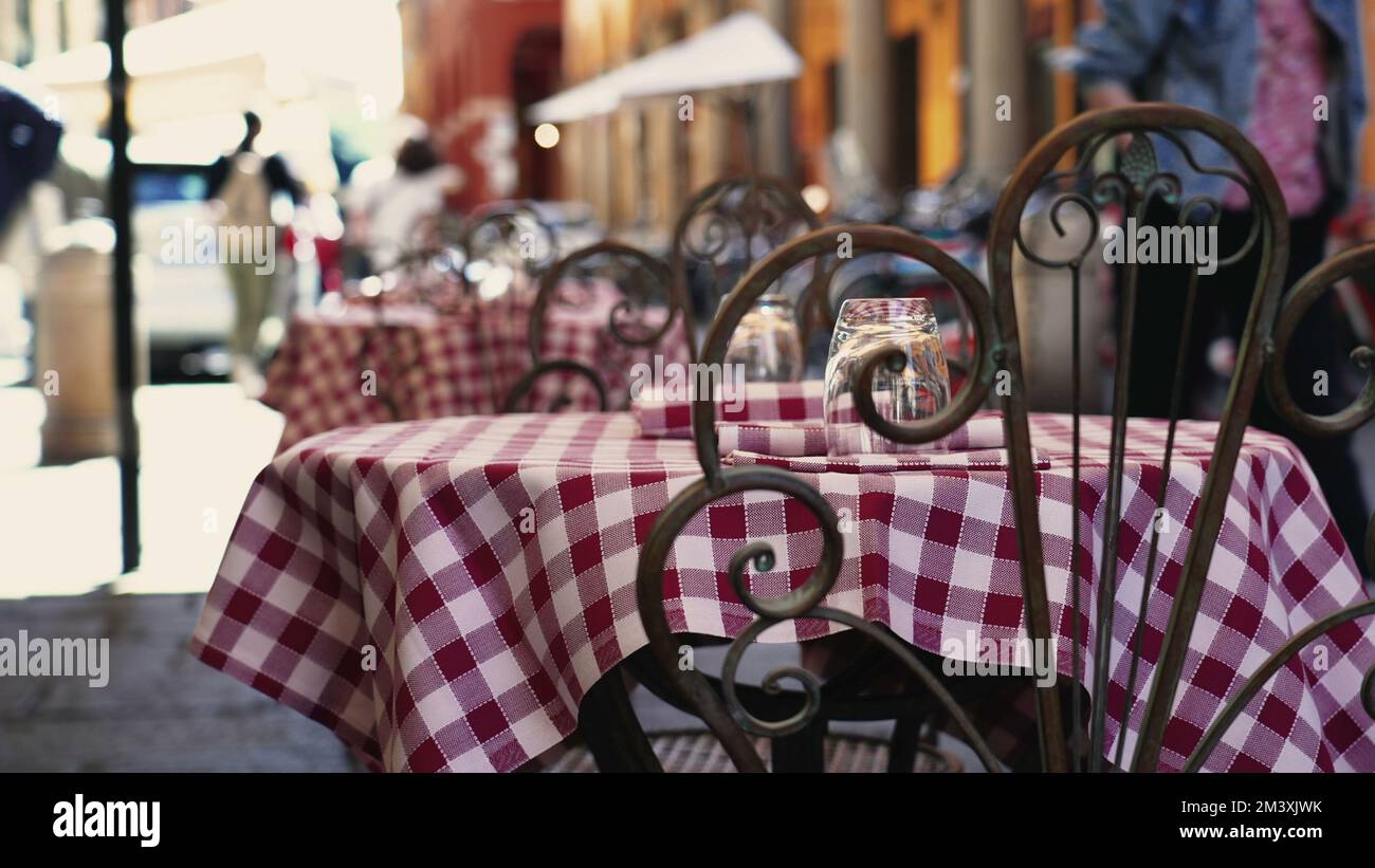 Italian Restaurant table with nobody. Wind flowing on tablecloth ...